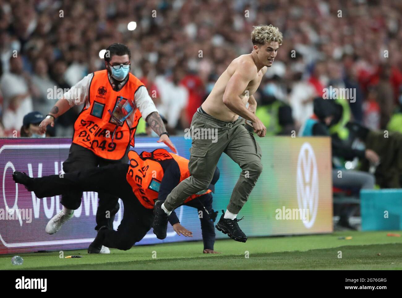 A pitch invader is chased by stewards during the UEFA Euro 2020 Final ...