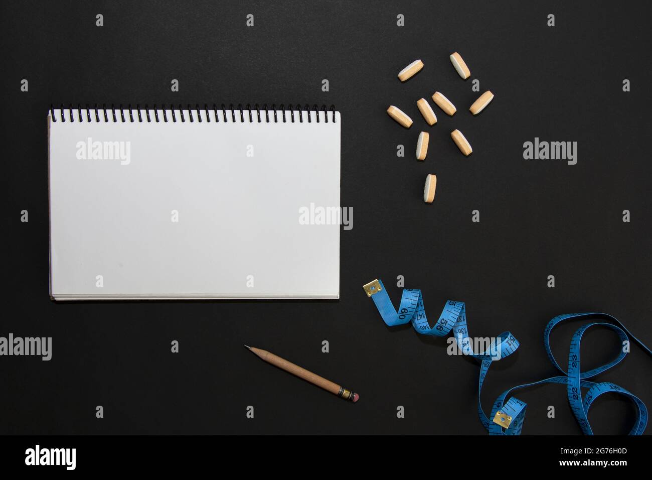 A closeup image of a horizontal notebook with a pencil and a blue ...