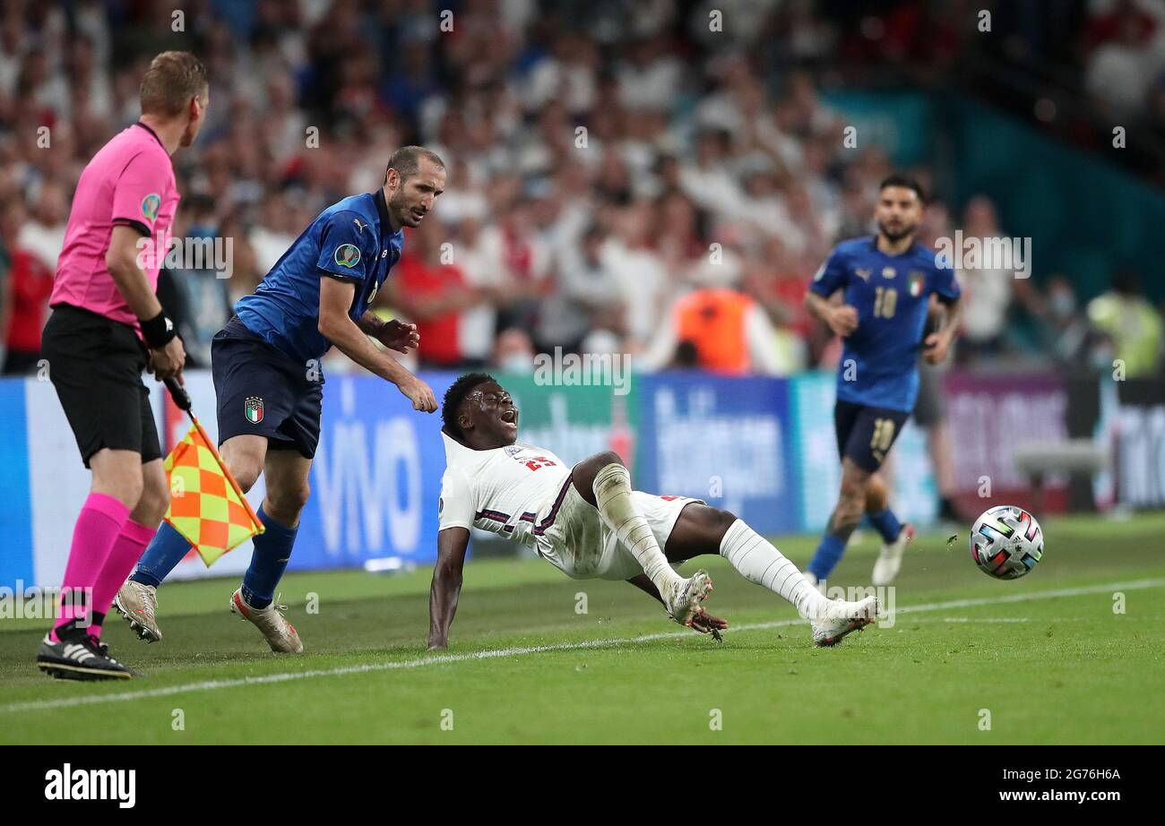Italy's Giorgio Chiellini (left) pulls back England's Bukayo Saka ...