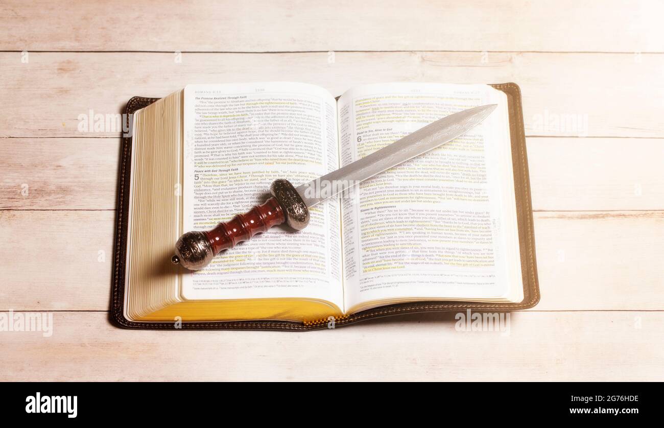 A Bible with a Sword on a Bright White Wooden Table Stock Photo - Alamy
