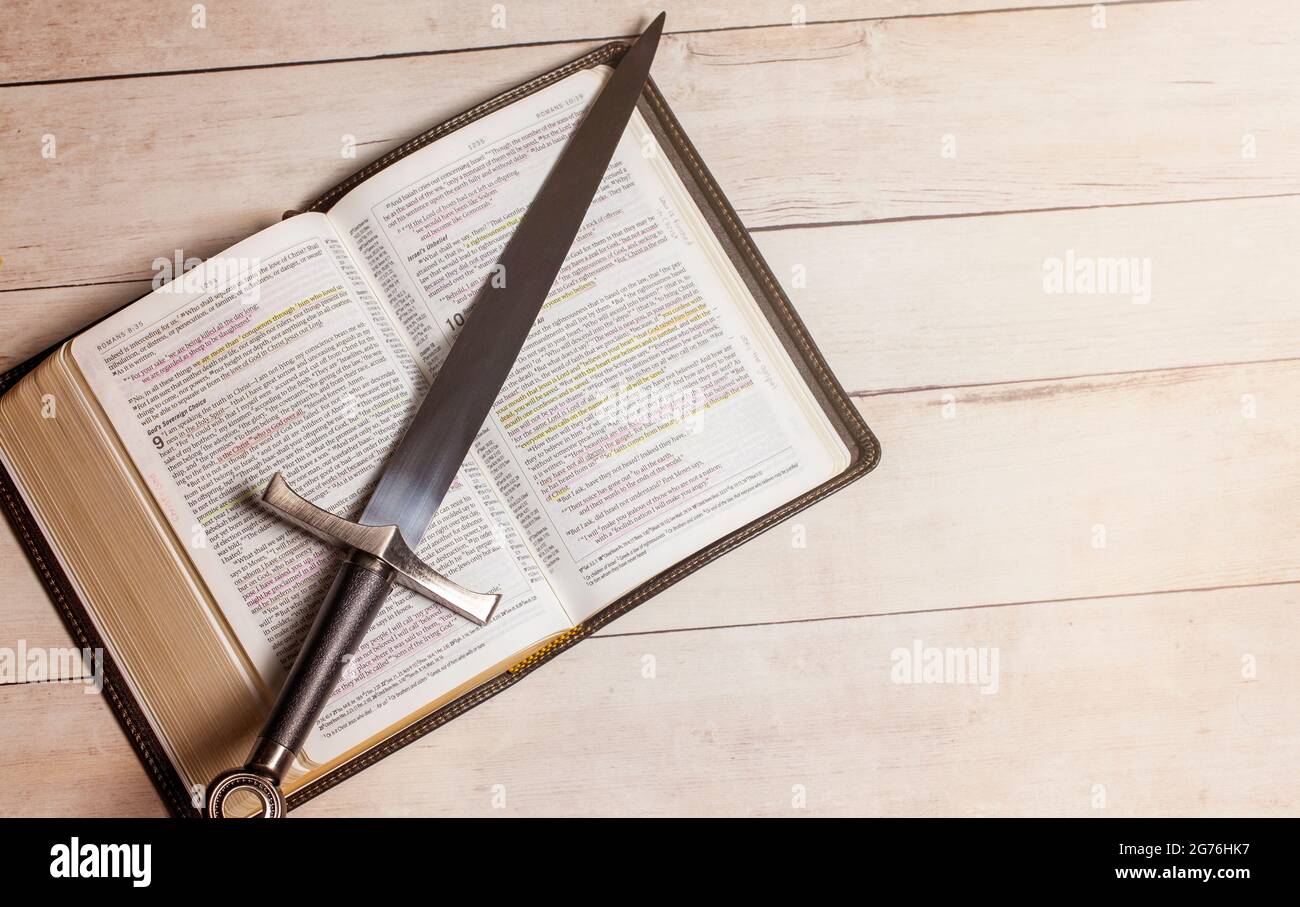 A Bible with a Sword on a Bright White Wooden Table Stock Photo - Alamy