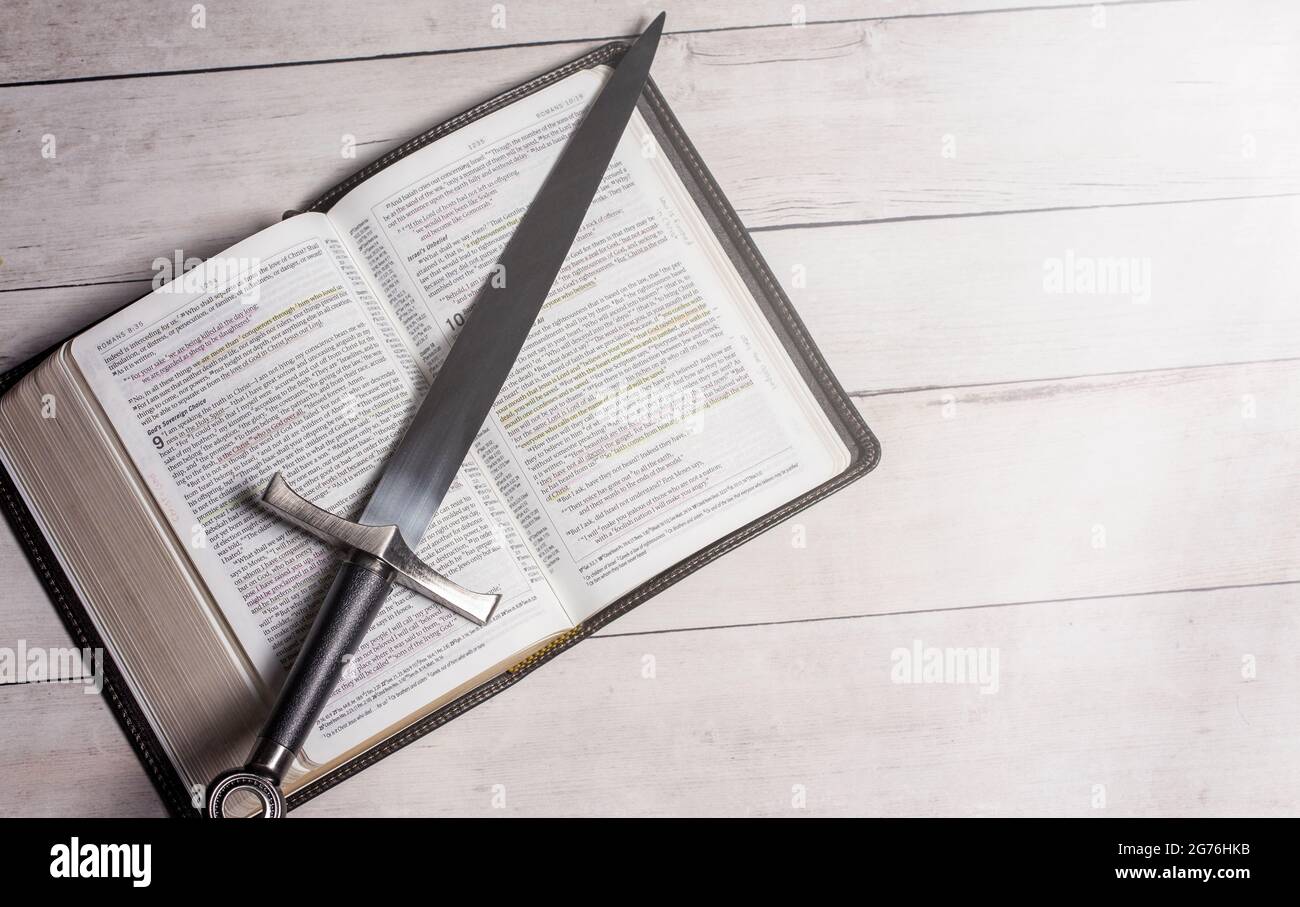 A Bible with a Sword on a Bright White Wooden Table Stock Photo - Alamy