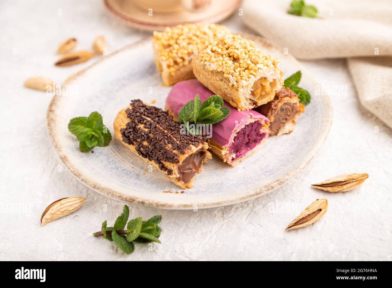 Set of eclair, traditional french dessert and cup of coffee on gray ...