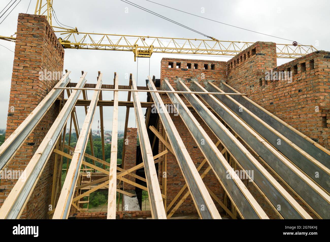 Unfinished brick apartment building with wooden roof structure under ...