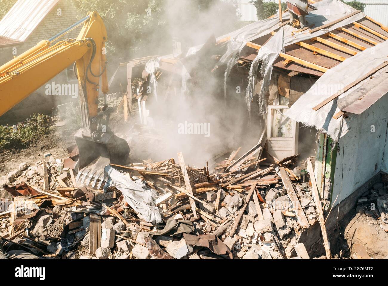 Destruction of old house by excavator. Bucket of excavator breaks ...