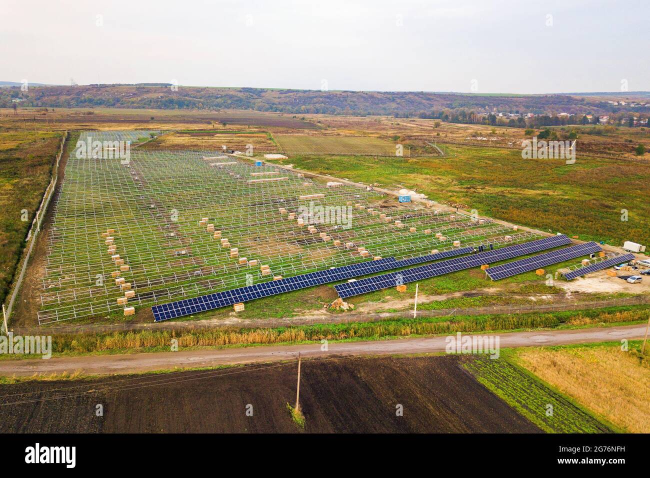 Aerial view of solar power plant under construction on green field ...