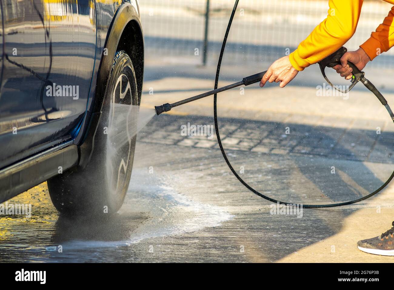 Closeup of male driver washing his car with contactless high pressure ...