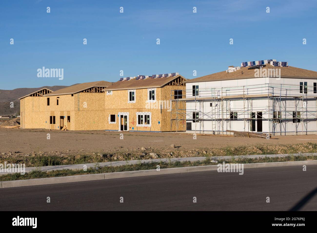 Roofing in progress, materials stacked on the top of a new building ...