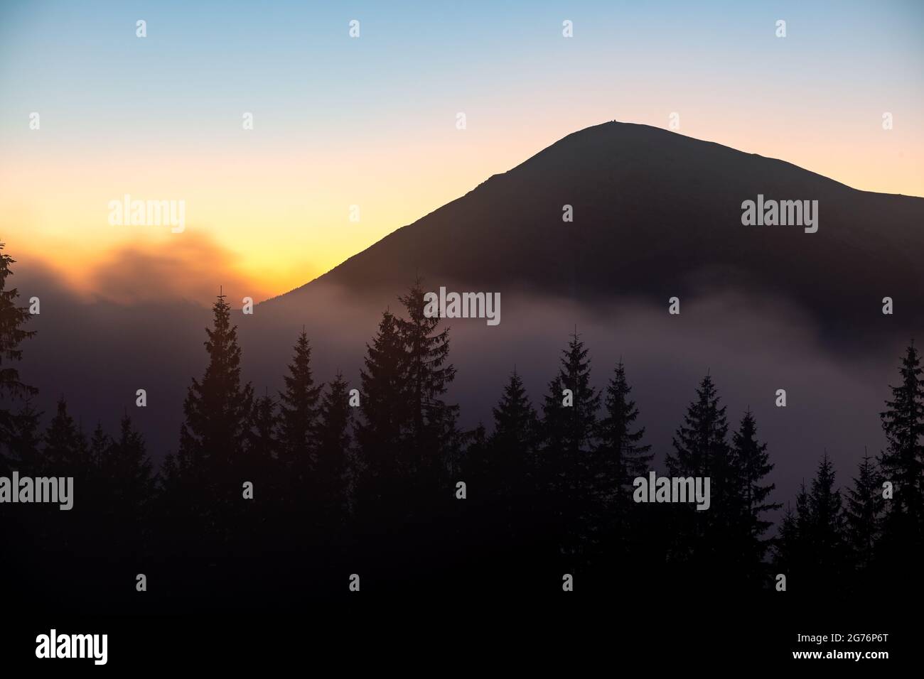 Beautiful mountain landscape with hazy peaks and foggy wooded valley at ...