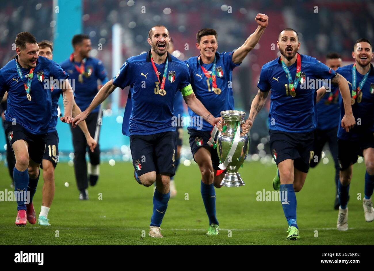 Italy's Giorgio Chiellini and Leonardo Bonucci carry the trophy and ...