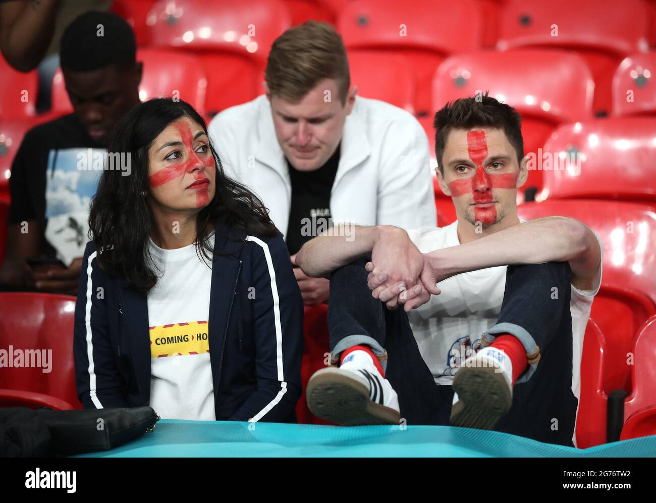 England fans sit dejected in the stands following defeat in the penalty ...