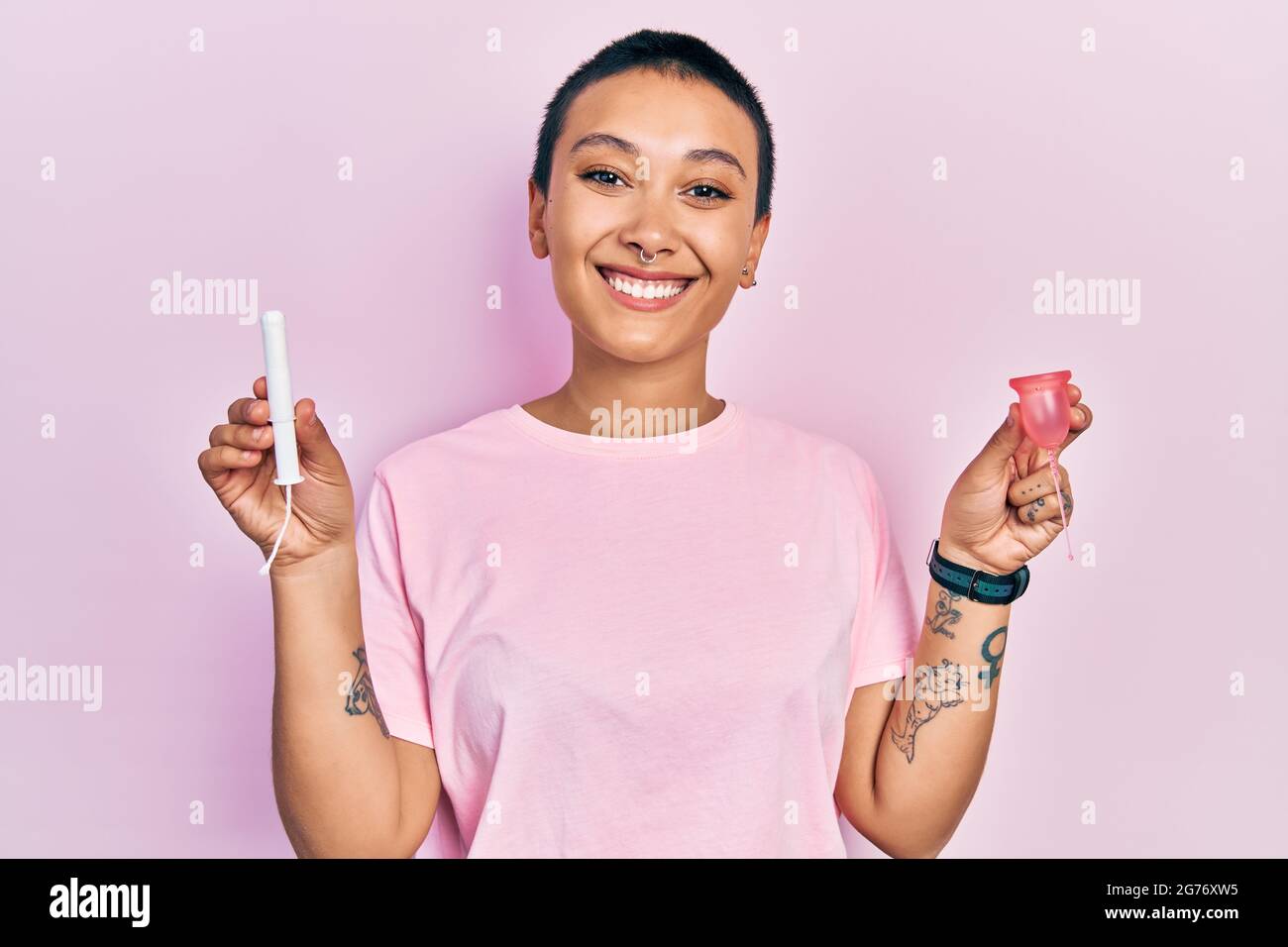 Beautiful hispanic woman with short hair holding menstrual cup and ...