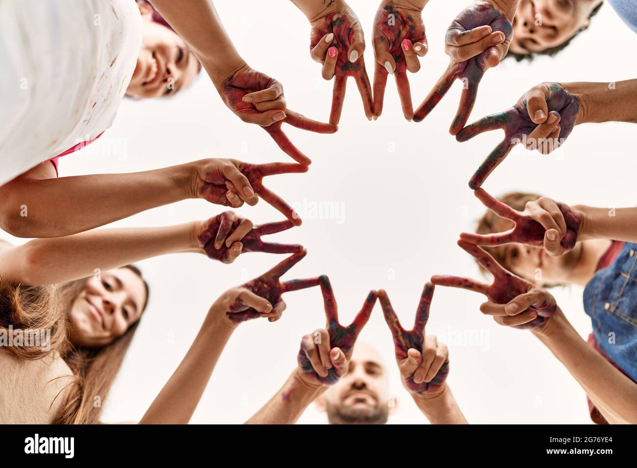 Group of young friends doing victory sign with fingers and hands ...