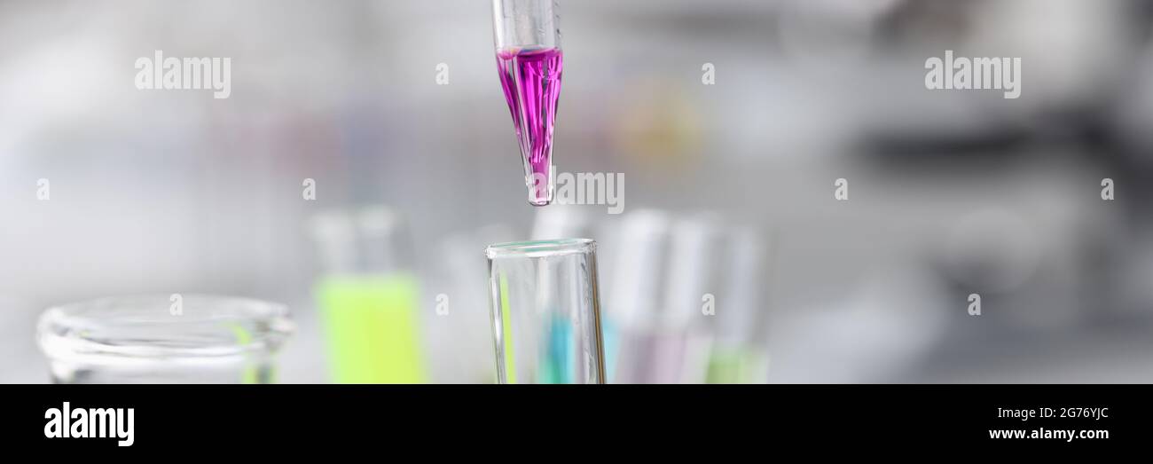 Purple liquid is dropped from pipette into test tube Stock Photo - Alamy