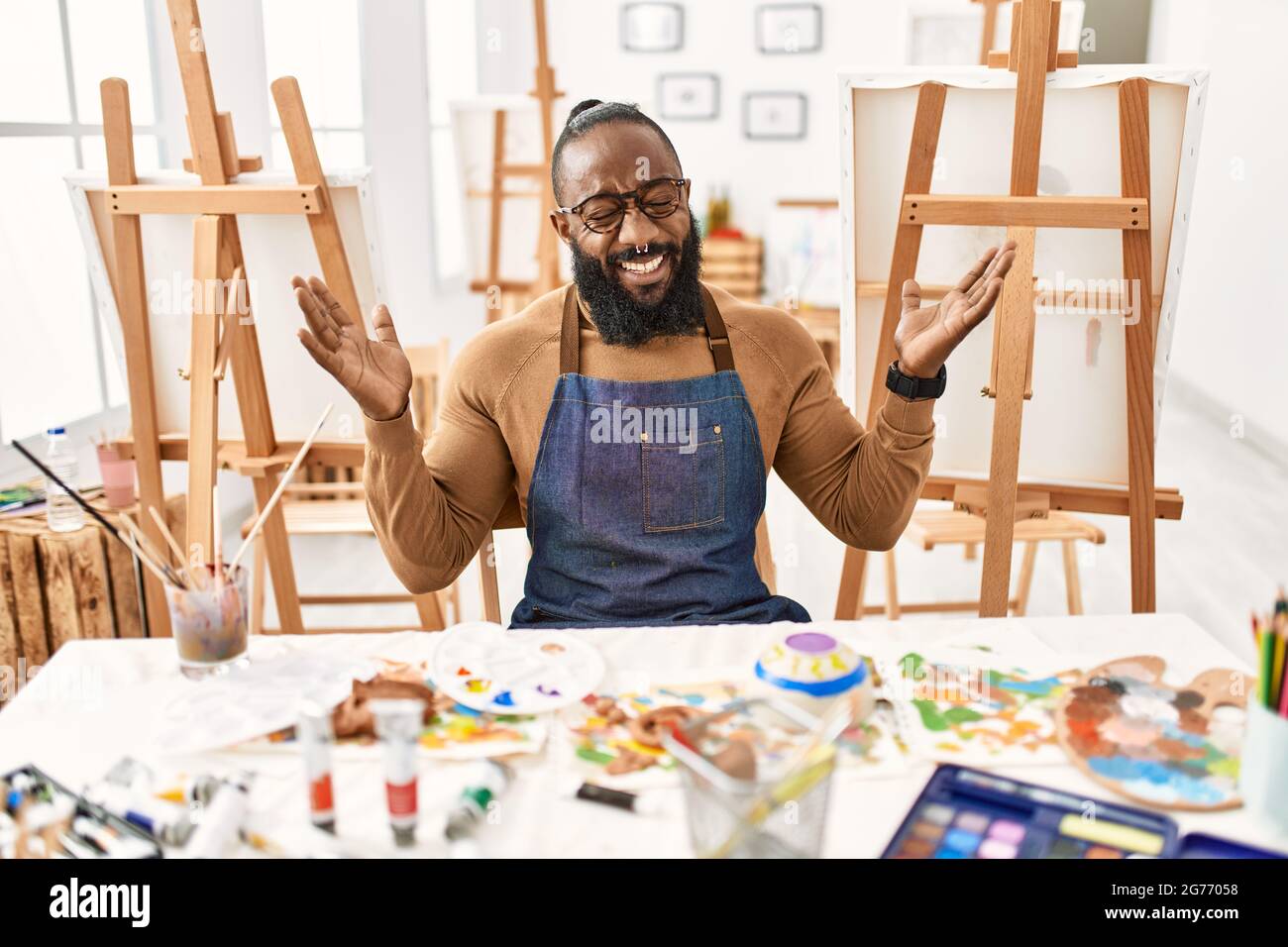 African american artist man at art studio celebrating mad and crazy for ...