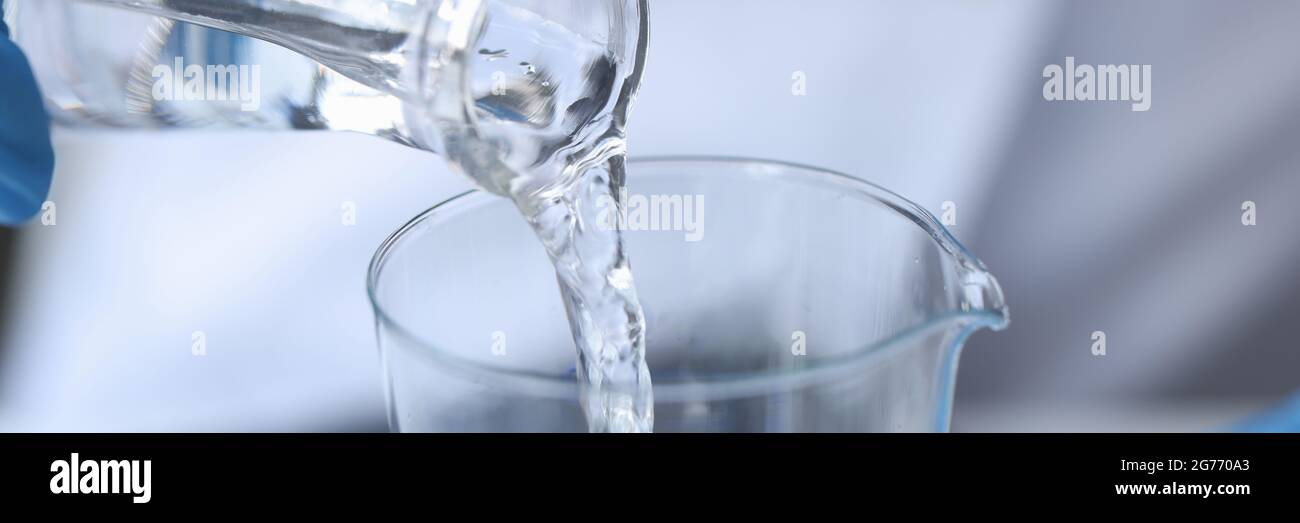 Clear liquid is poured from glass bottle Stock Photo - Alamy