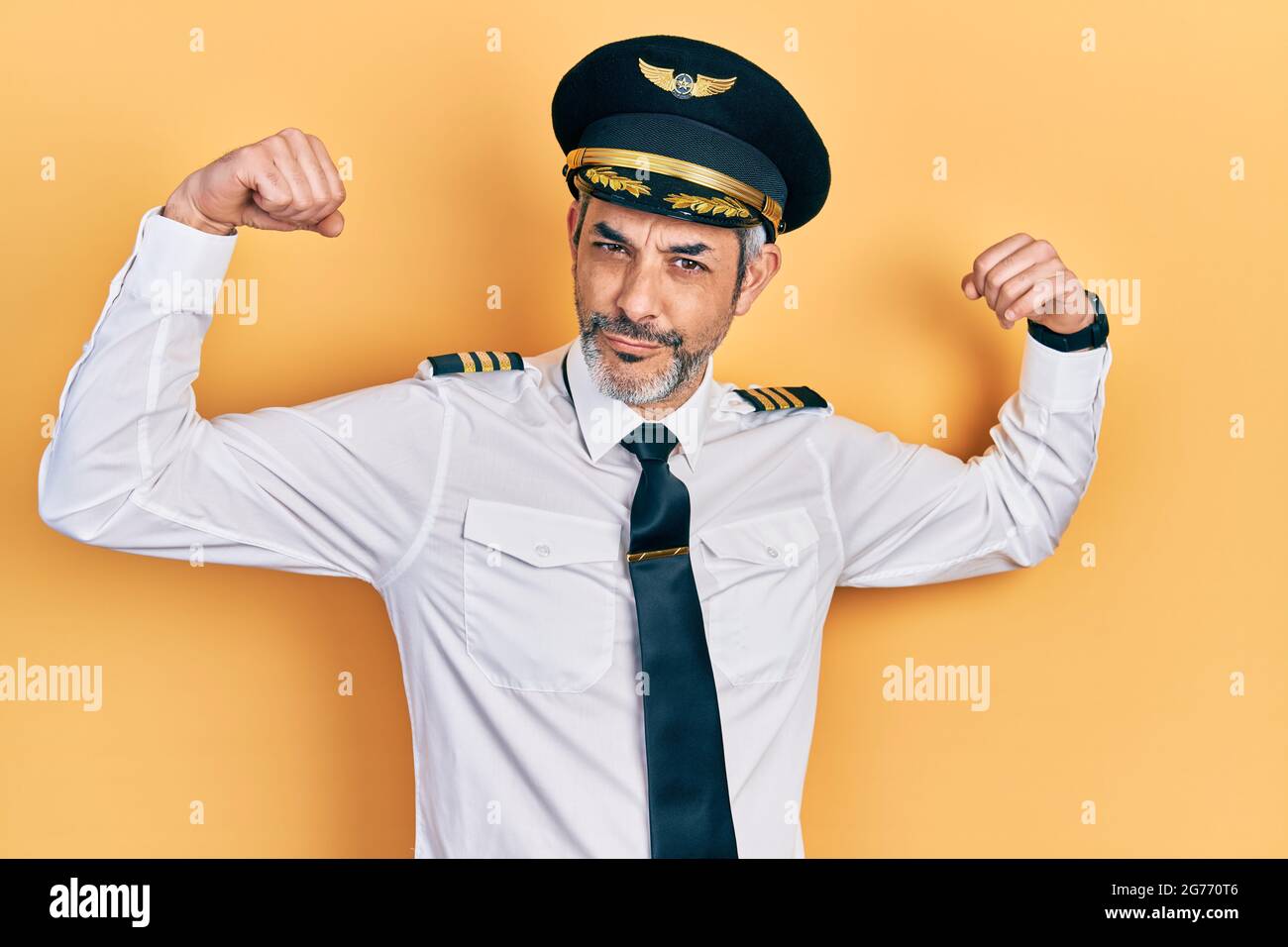 Handsome middle age man with grey hair wearing airplane pilot uniform ...