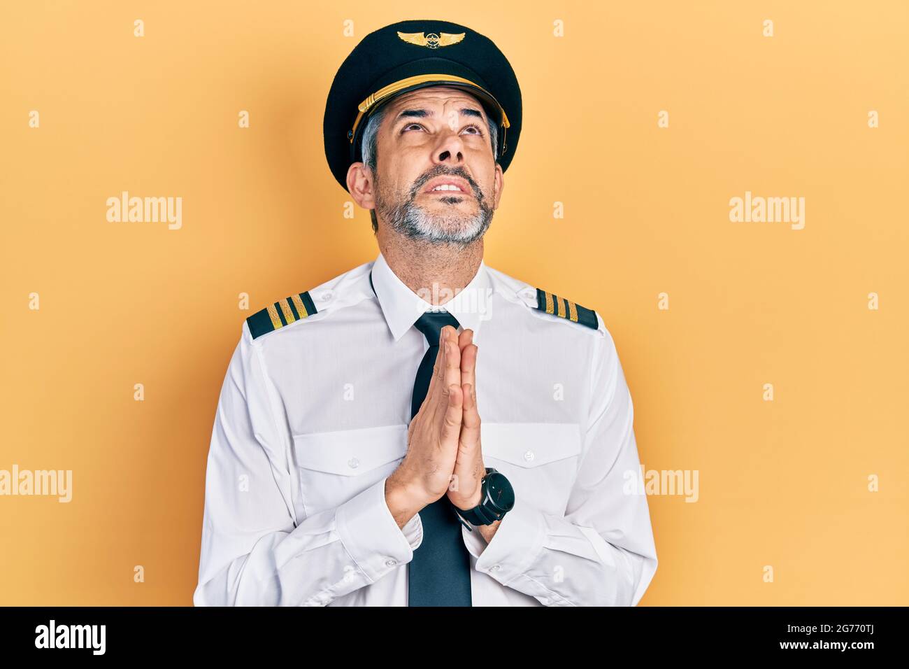 Handsome middle age man with grey hair wearing airplane pilot uniform ...