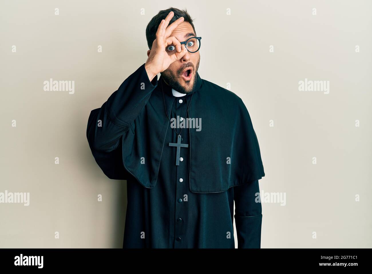 Young hispanic man wearing priest uniform standing over white ...