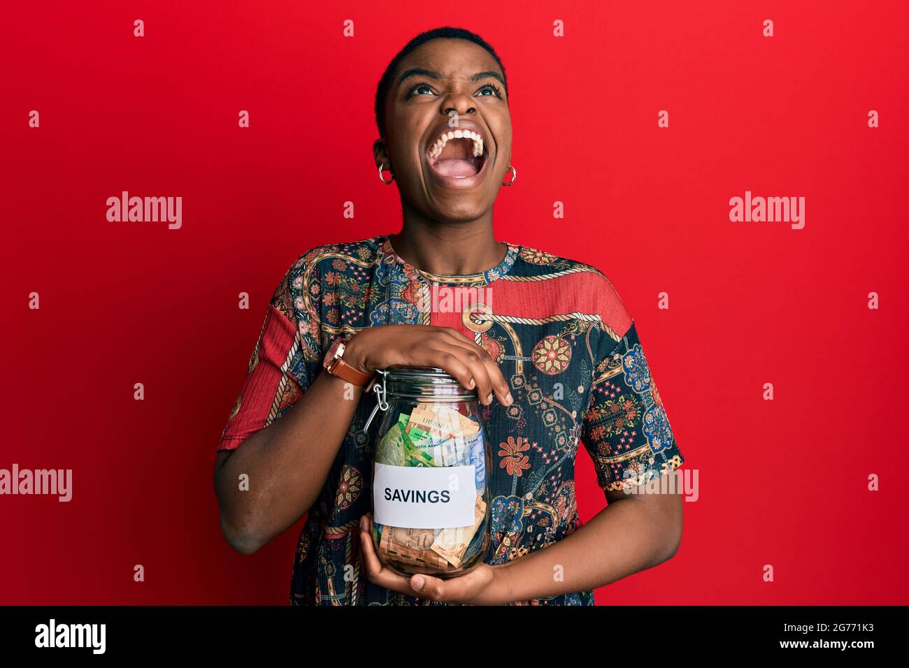 Young african american woman holding savings jar with south african ...