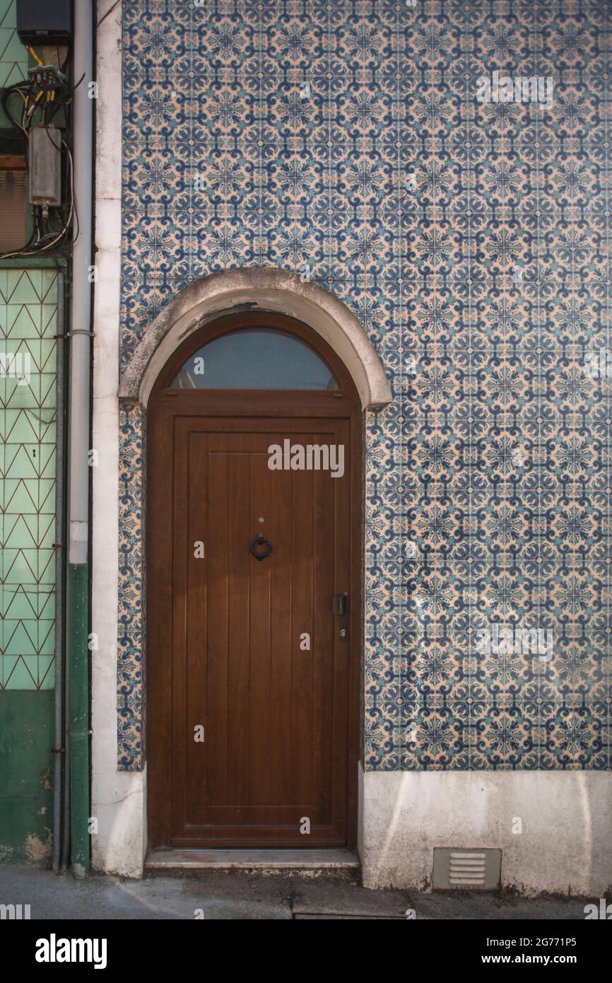 The door to the traditional Portuguese building. Old tiles wall on the ...