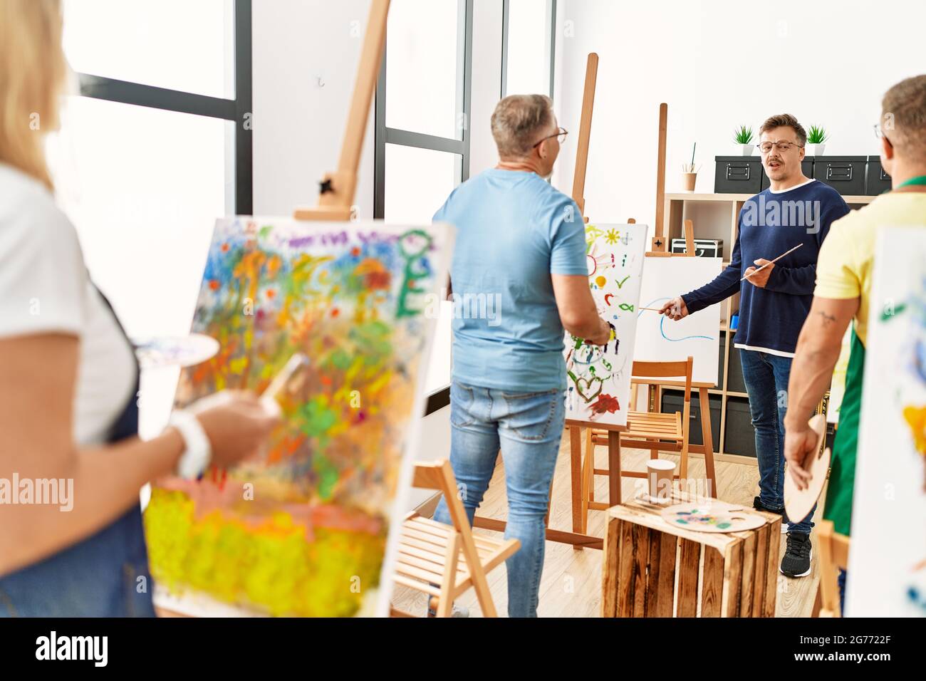 Group of middle age paint students having art class at drawing studio ...