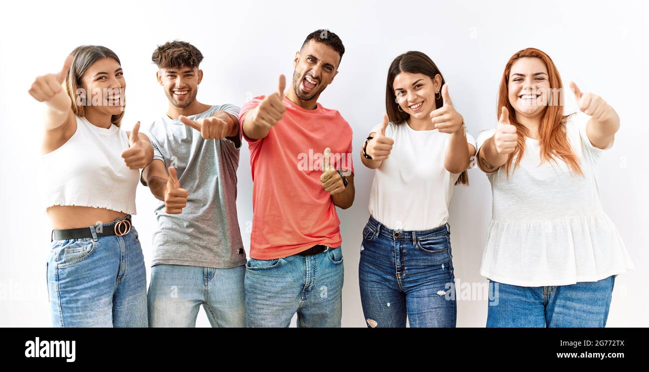 Group of young friends standing together over isolated background ...