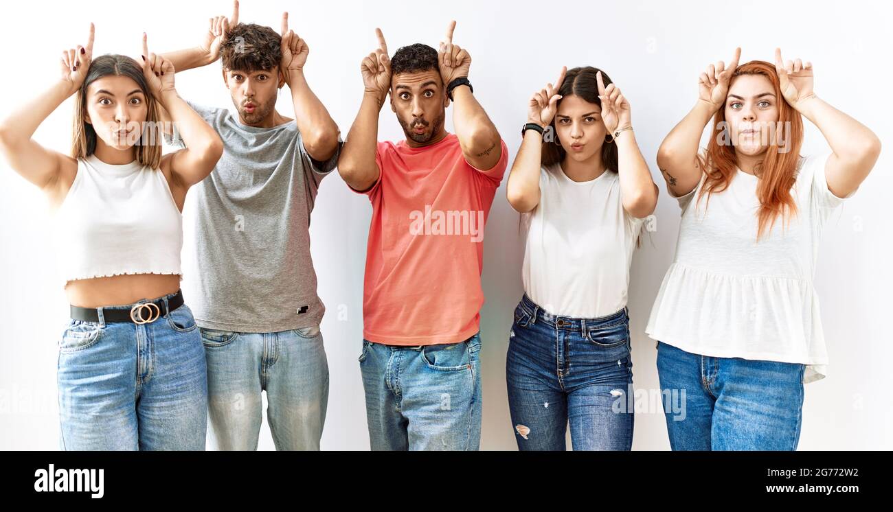 Group of young friends standing together over isolated background doing ...