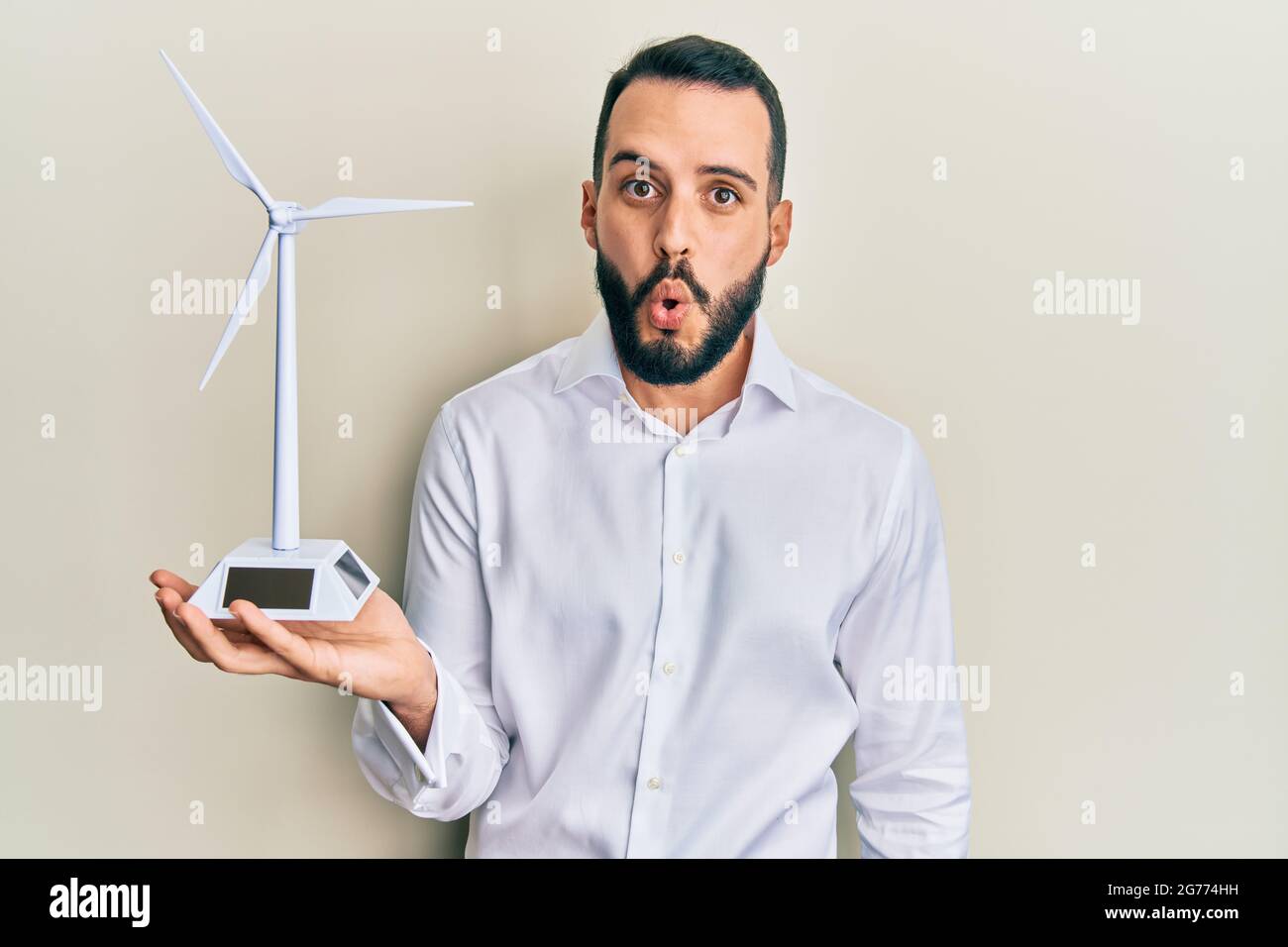 Young man with beard holding solar windmill for renewable electricity ...