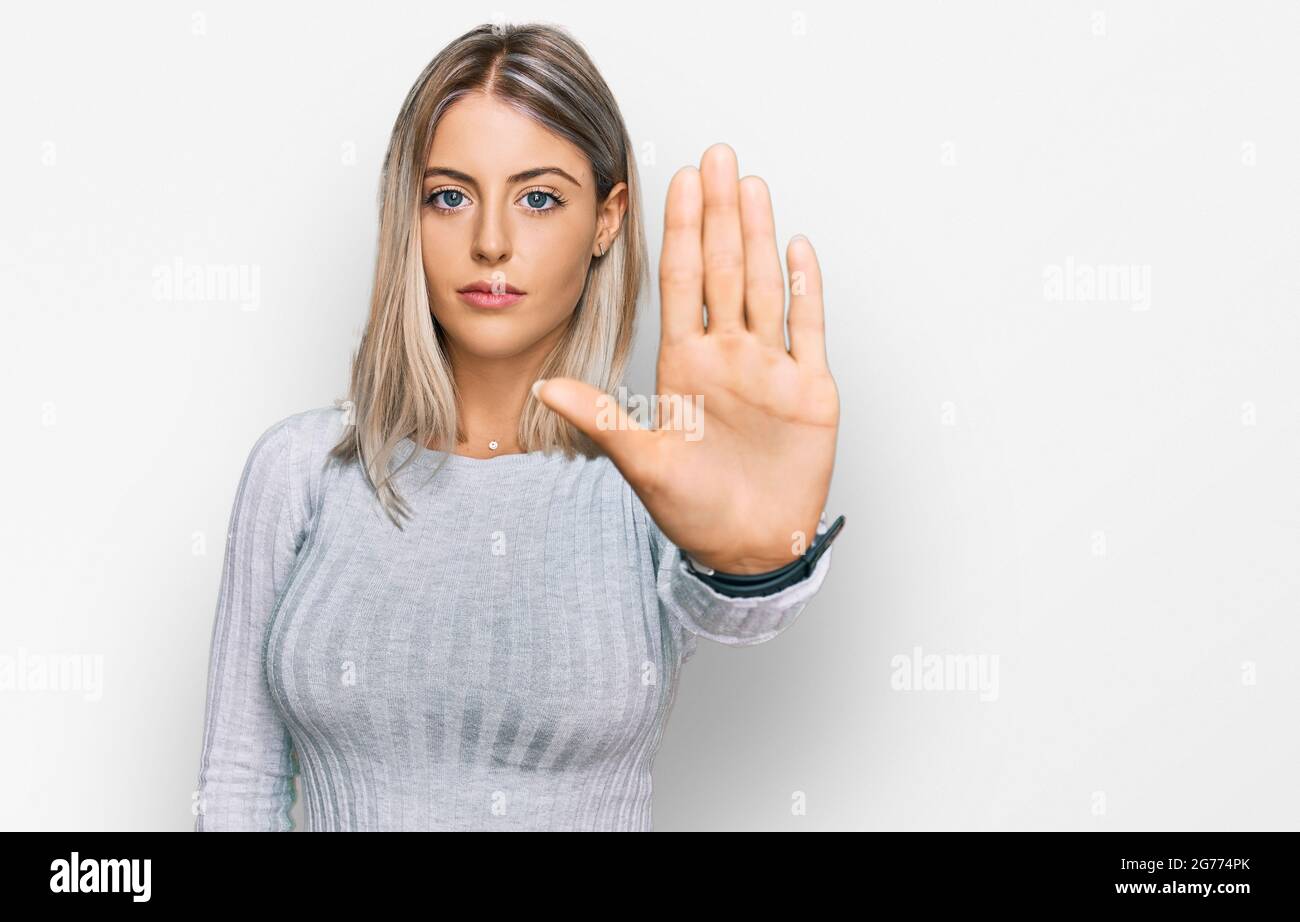 Beautiful blonde woman wearing casual clothes doing stop sing with palm ...