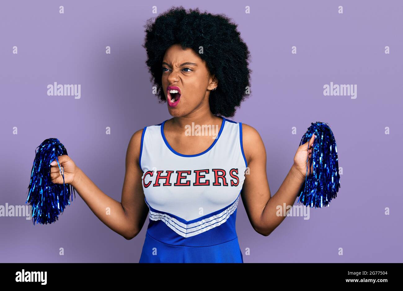 Young african american woman wearing cheerleader uniform using pompom ...