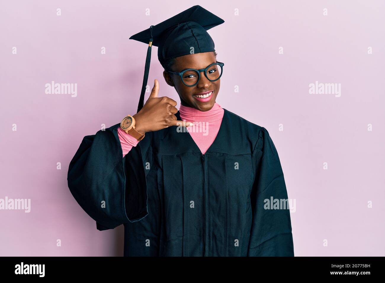 Young african american girl wearing graduation cap and ceremony robe ...