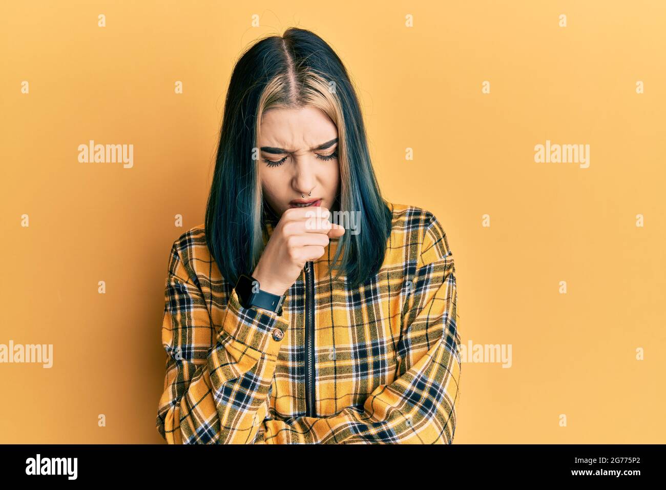 Young modern girl wearing casual yellow shirt feeling unwell and ...