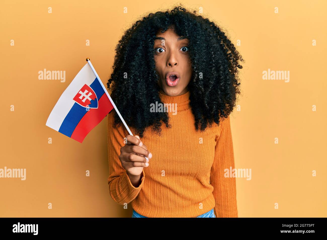 African american woman with afro hair holding slovakia flag scared and ...