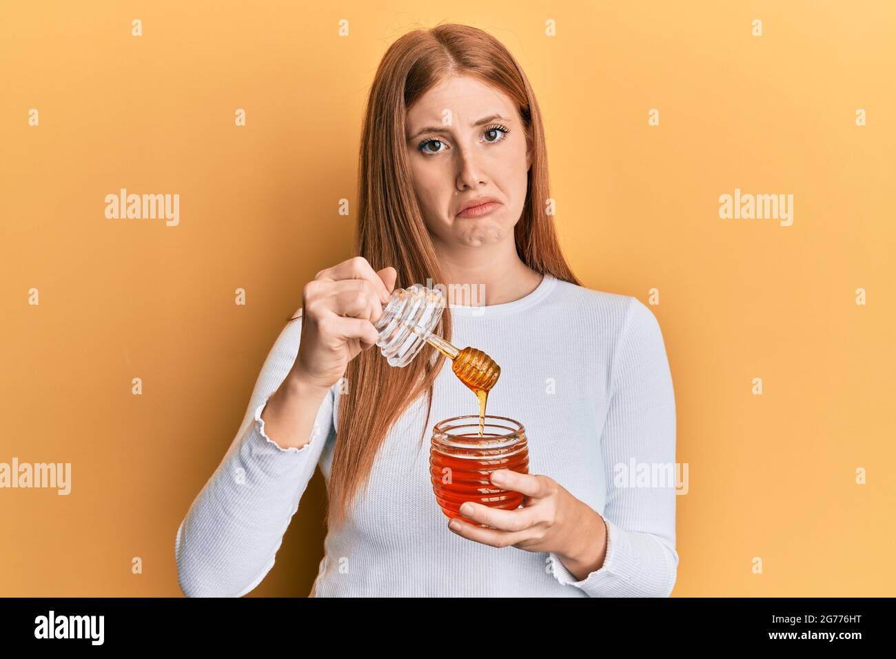 Young irish woman holding honey depressed and worry for distress ...