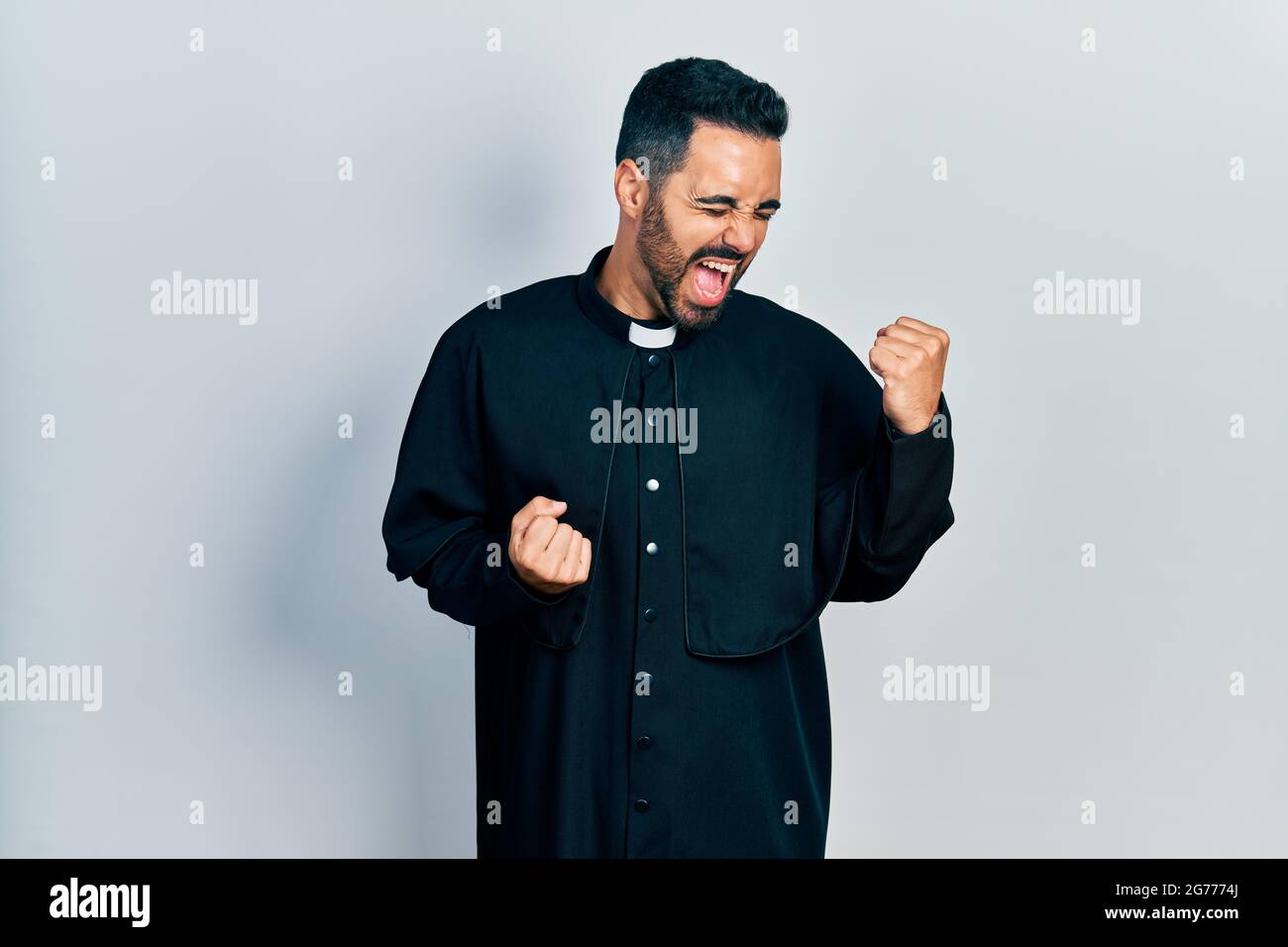 Handsome hispanic man with beard wearing catholic priest robe ...
