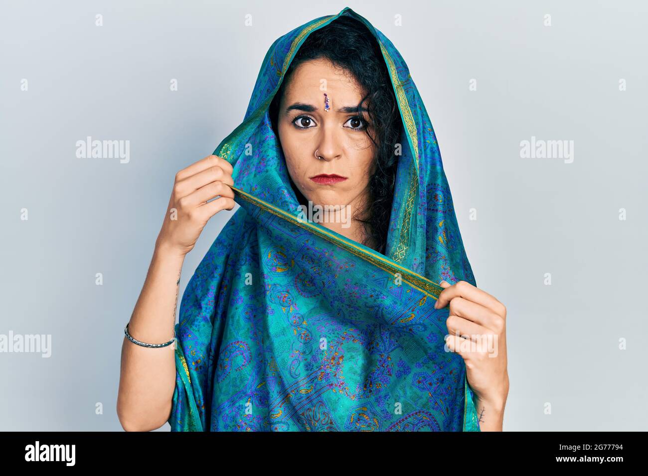Young woman wearing bindi wearing traditional indian saree with hand on ...