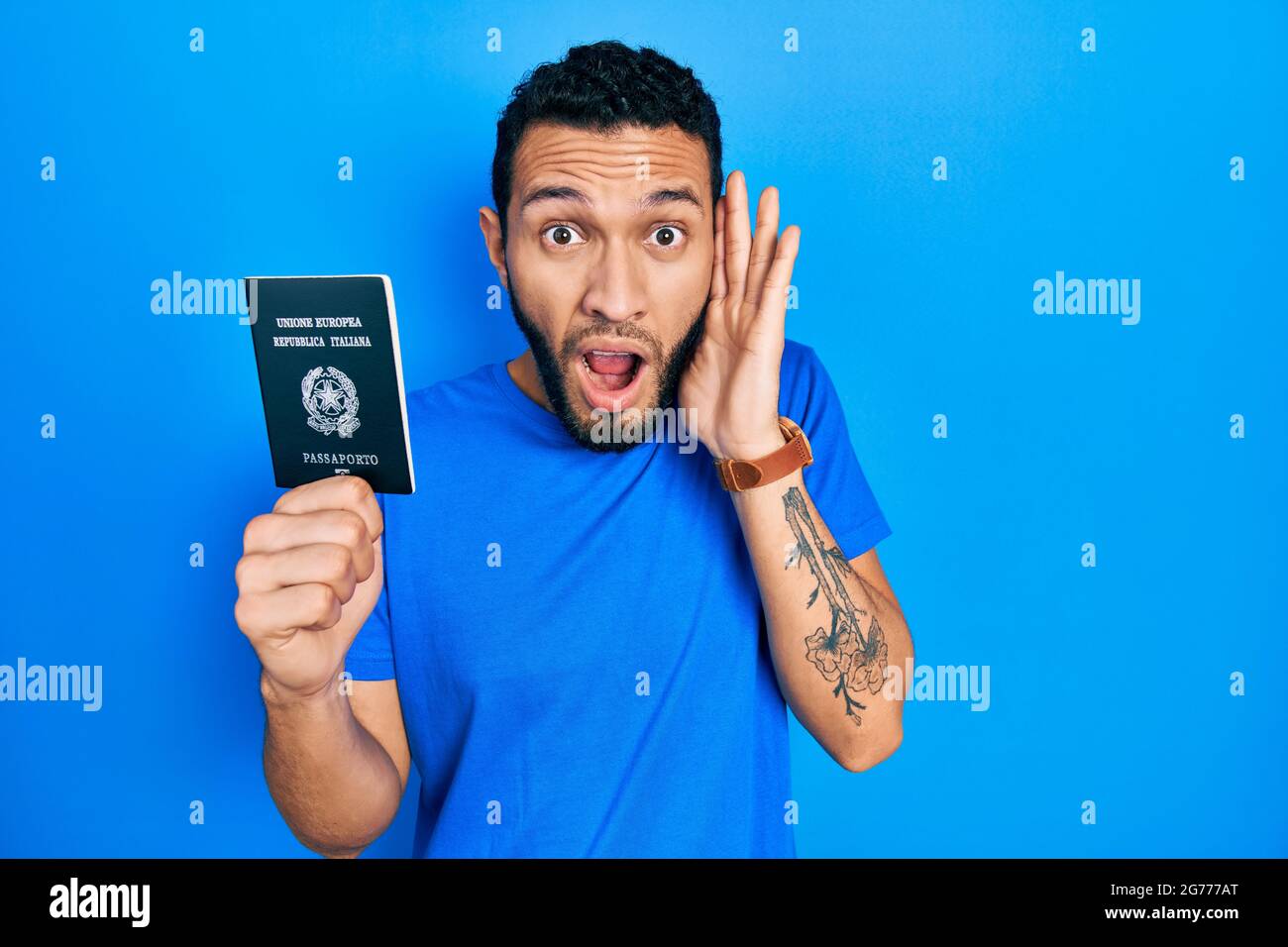 Hispanic man with beard holding italy passport afraid and shocked ...
