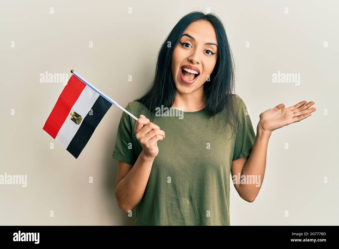 Young hispanic girl holding egypt flag celebrating achievement with ...