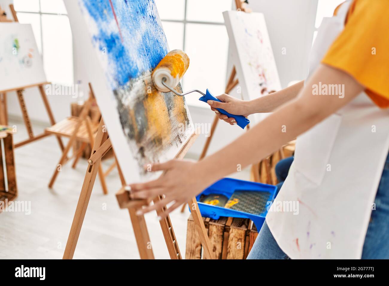 Woman paint student painting using roller at art studio Stock Photo - Alamy