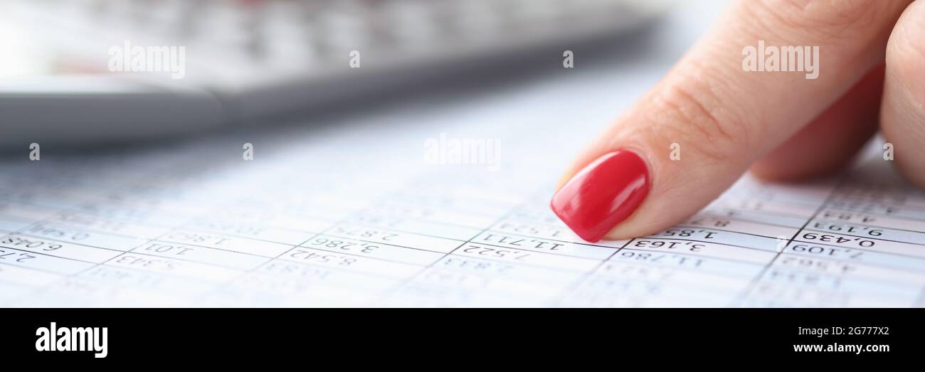 Woman pointing her index finger at numbers in table and counting on ...