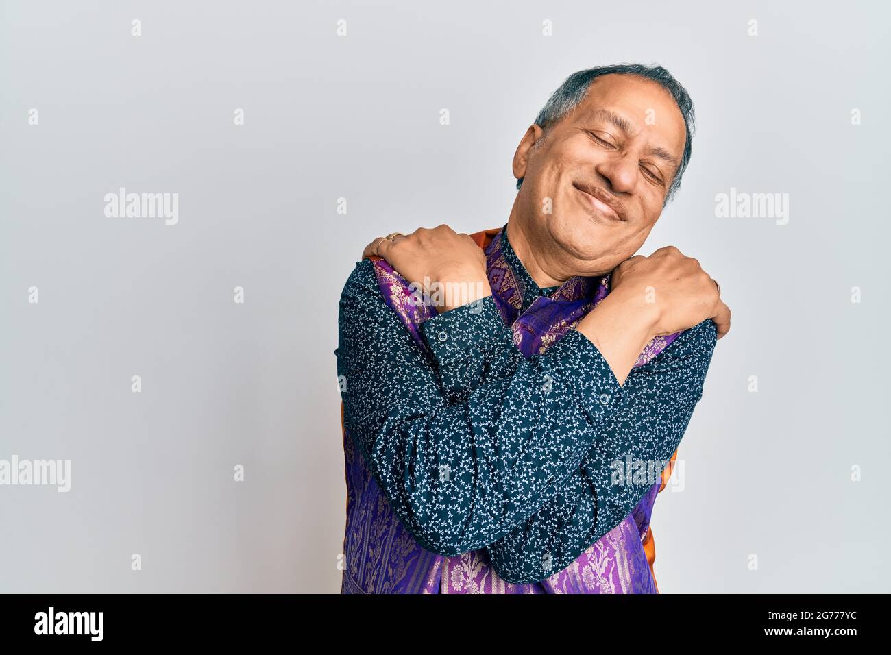 Middle age indian man wearing traditional indian clothes hugging ...