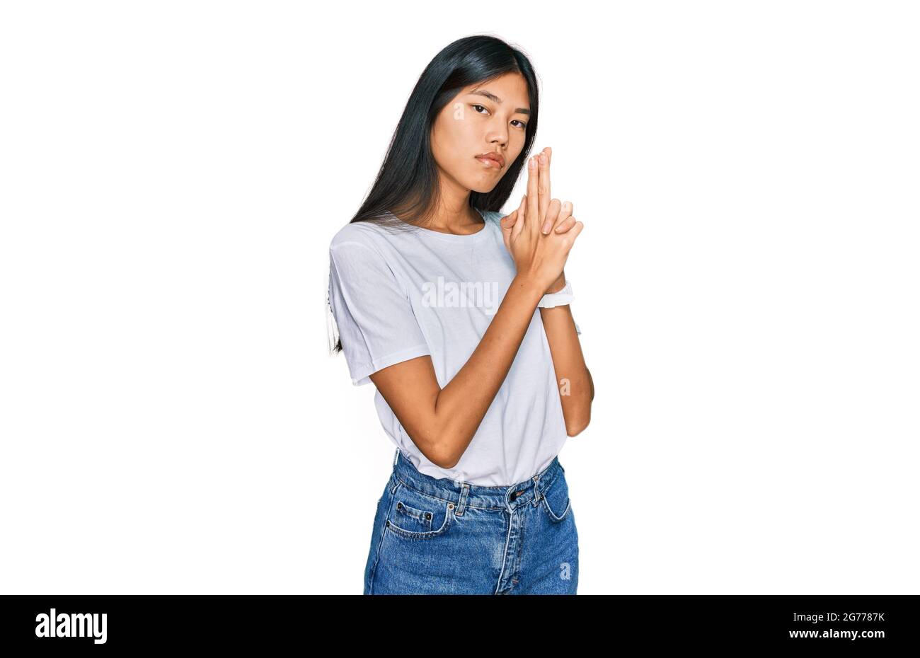 Beautiful young asian woman wearing casual white t shirt holding ...