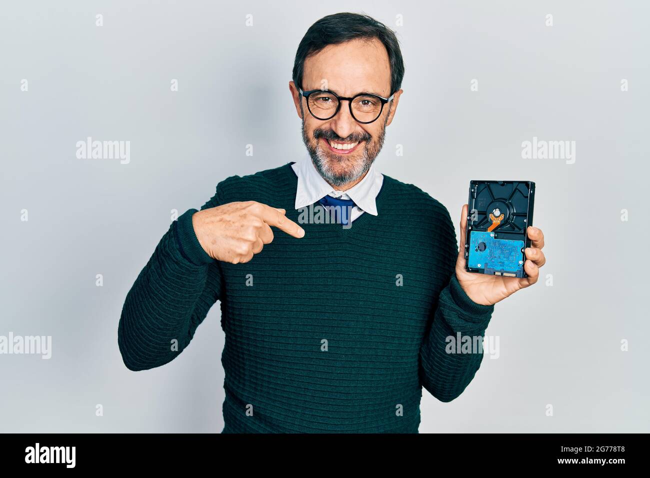 Middle age hispanic man holding hdd disk pointing finger to one self ...