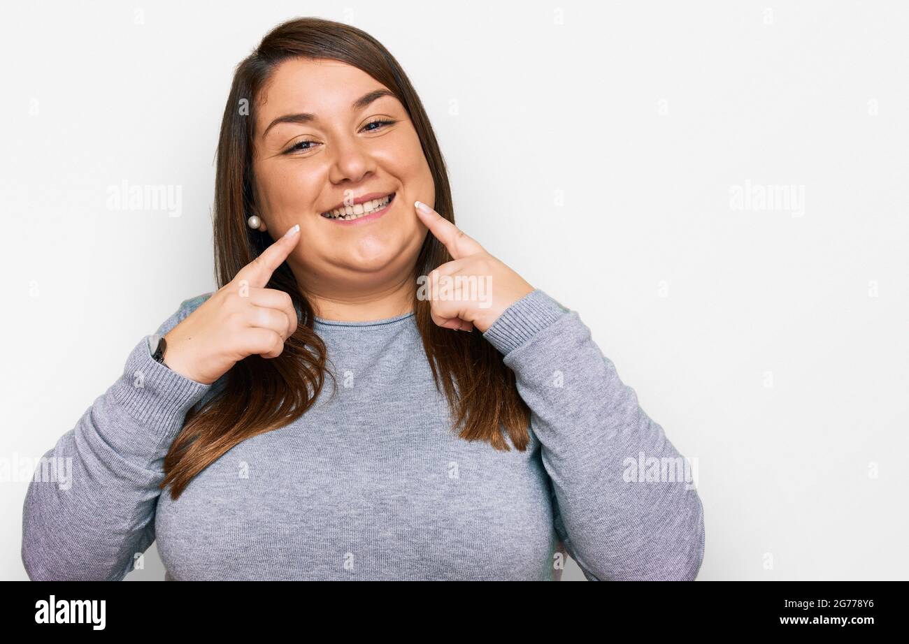 Beautiful brunette plus size woman wearing casual clothes smiling with ...