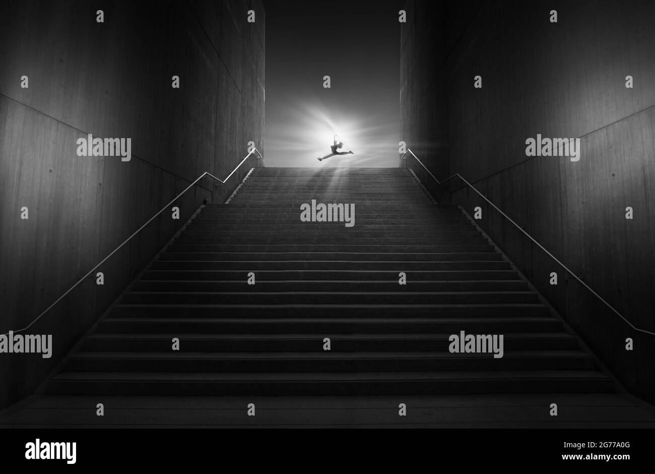 Grayscale shot of a woman doing a famous ballet pose against sunlight ...