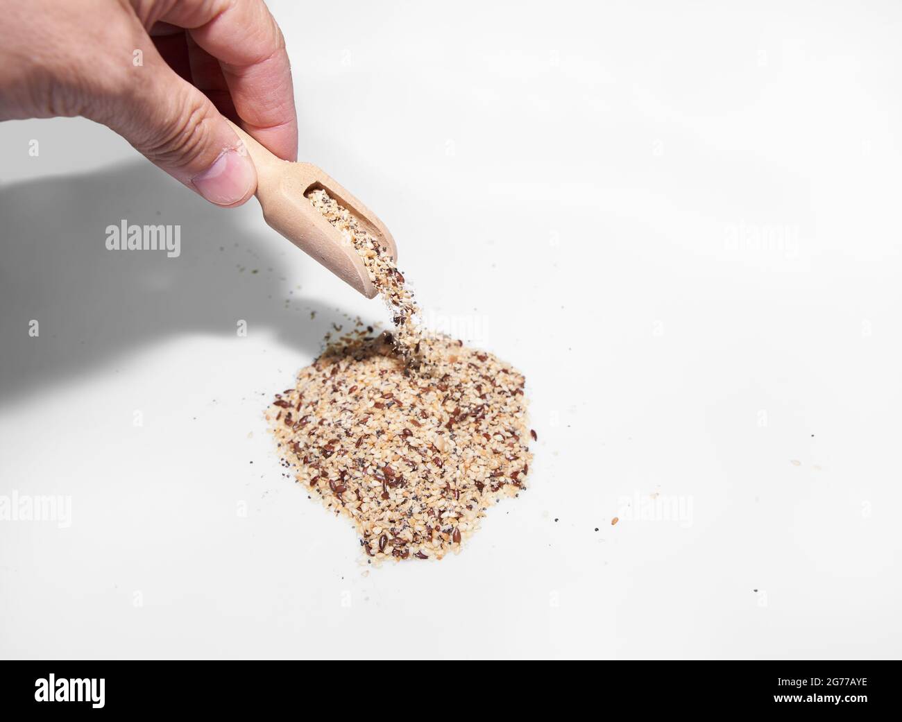 Close up of hand throwing seeds into a pile. Studio shot on white ...