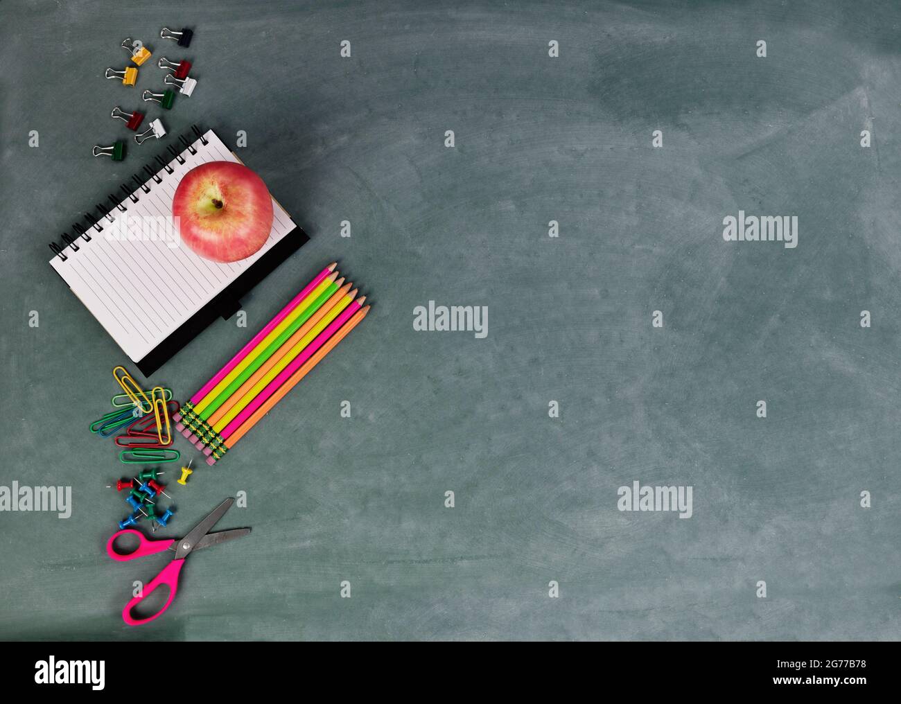 Back to school with education supplies on green chalkboard in flay lay ...