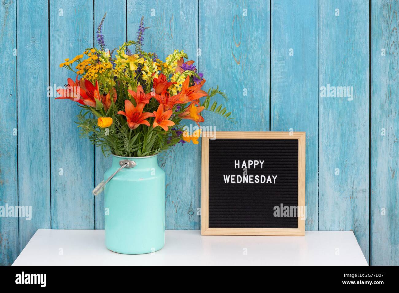 Happy Wednesday words on black letter board and bouquet of bright ...