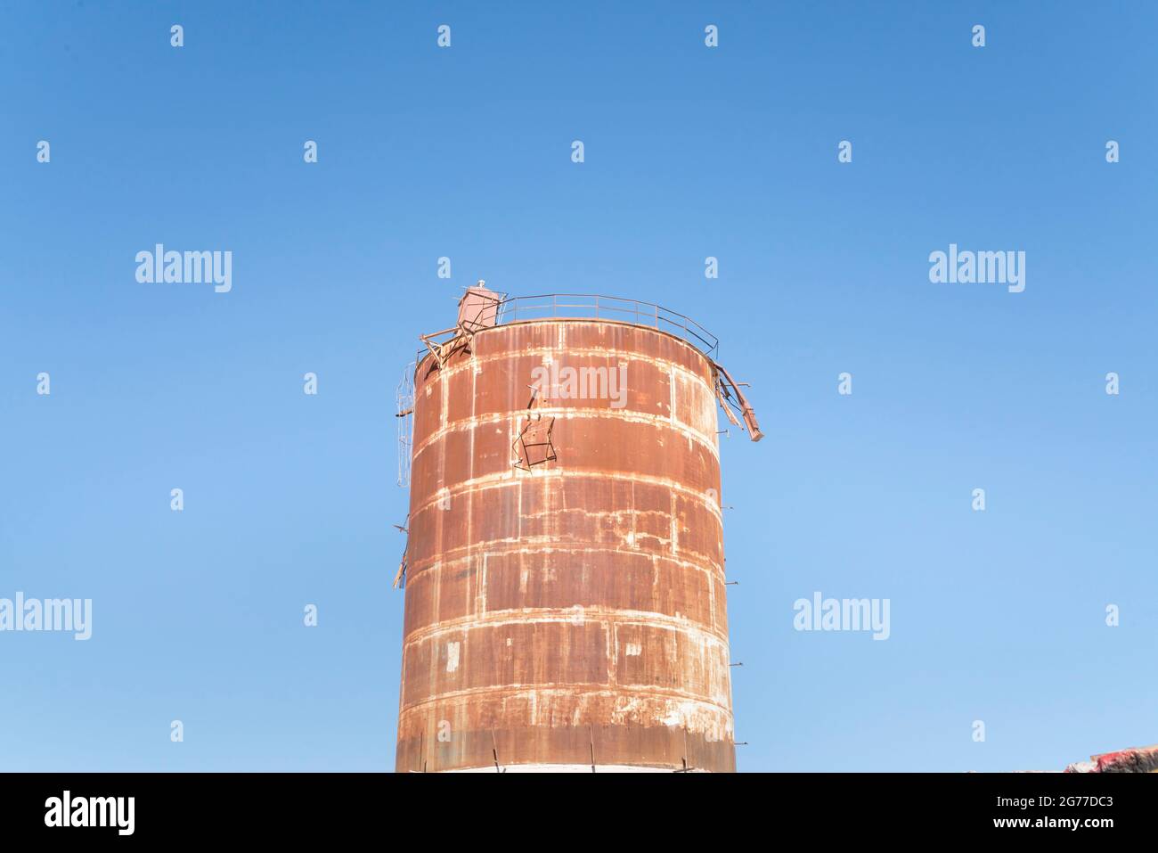 Low angle view of an abadoned silo cylinder tower against a clear blue ...